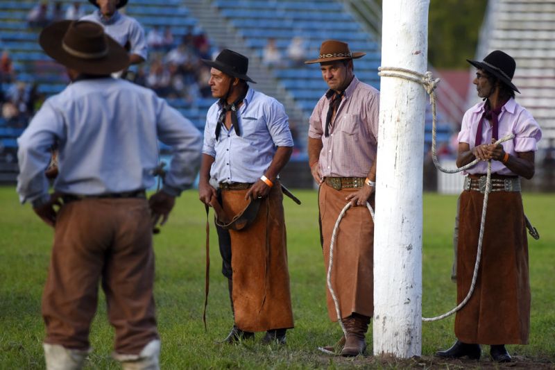 Gauchos ride wild horses at rodeo celebrating Criolla Week
