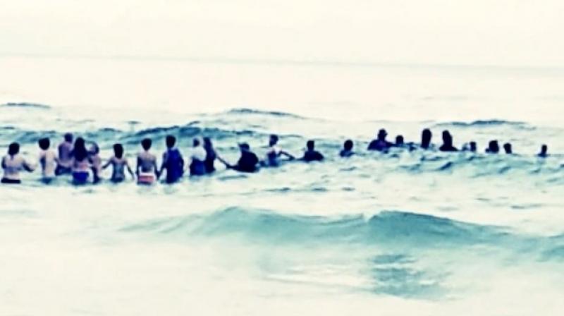 Beachgoers form massive human chain to rescue drowning family